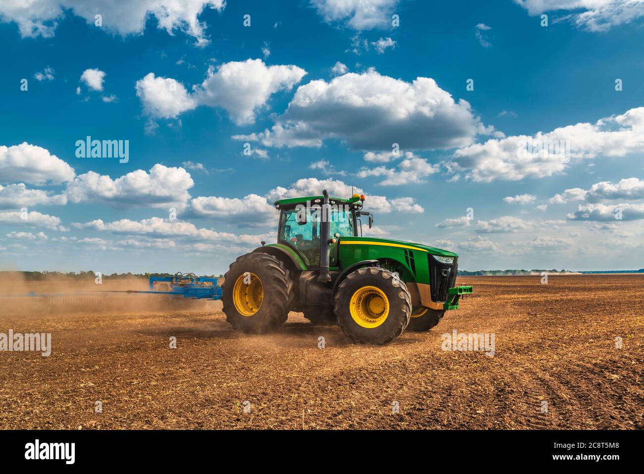 Big tractor on the cultivated field. Agricultural industry. Soil ...