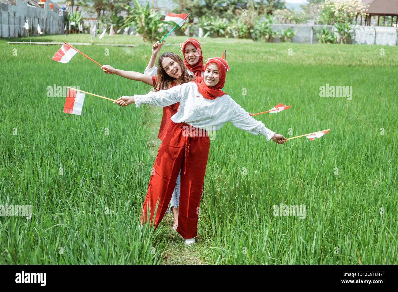 group of young Asian people smiling holding small flags stand on rice ...