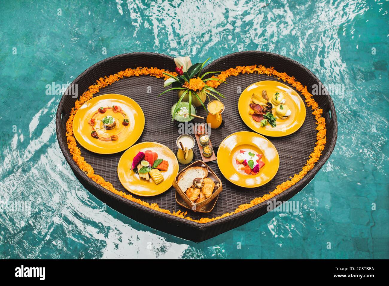 Floating breakfast in jungle swimming pool, tropical resort. Black ...