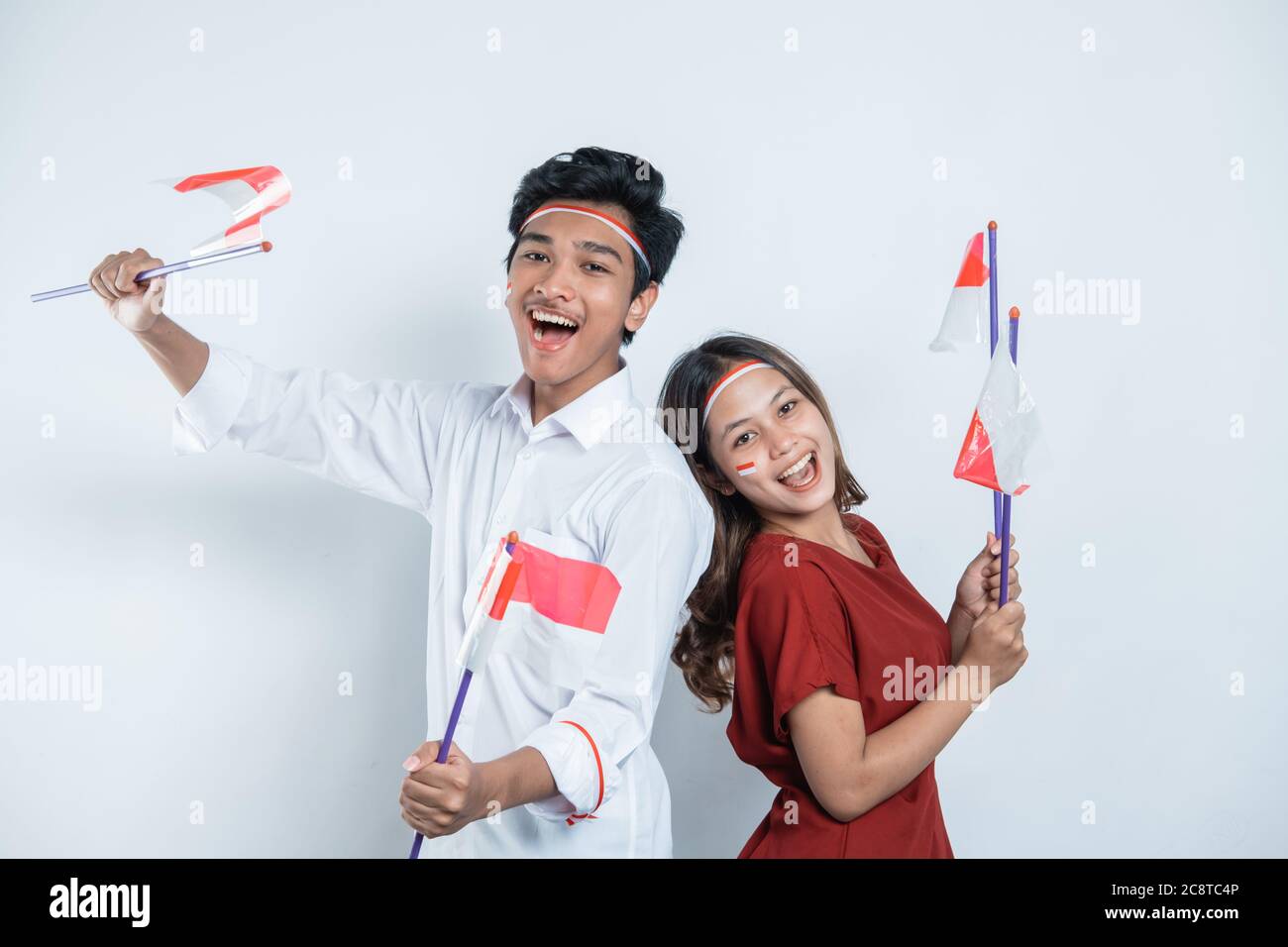 young couple holding a small Indonesian flags and wearing the red and ...