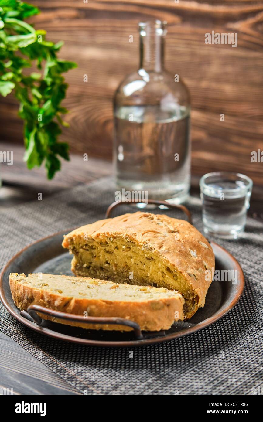 Homemade bread with pumpkin seeds and frozen vodka on rustic background ...