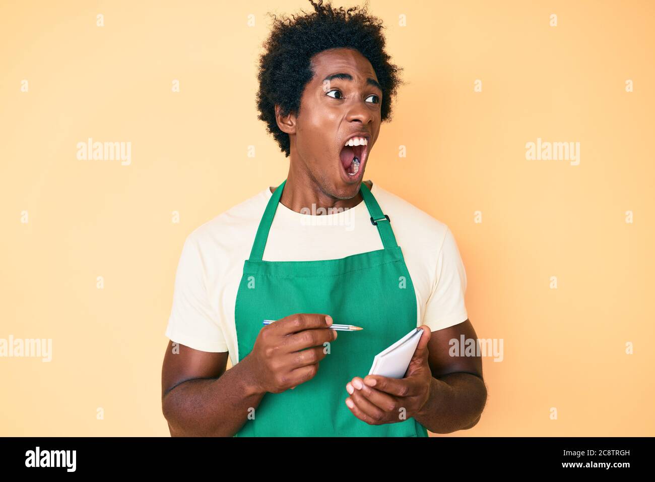 Handsome african american man with afro hair wearing waiter apron ...