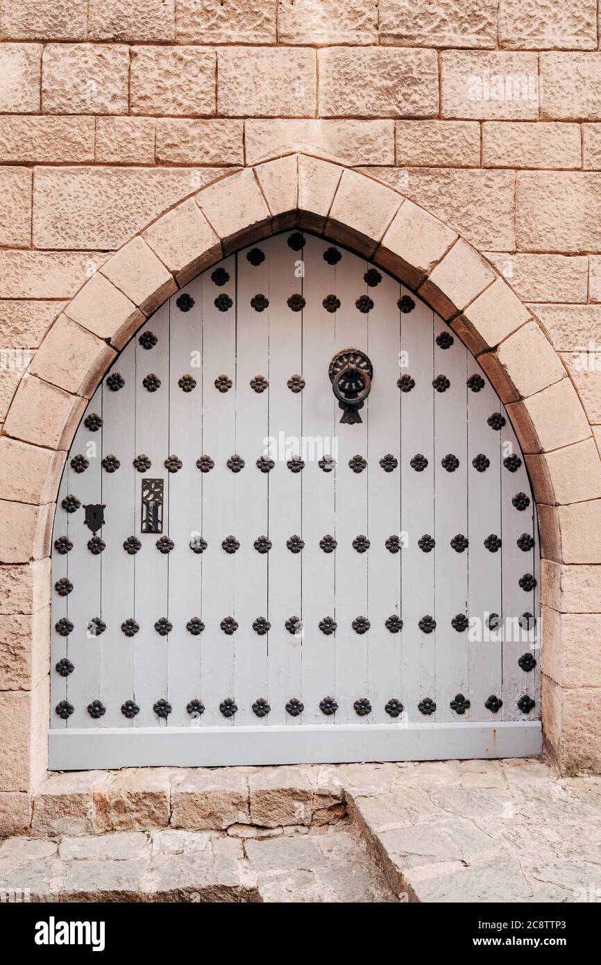 The entrance to the building is made of white large doors with a metal ...