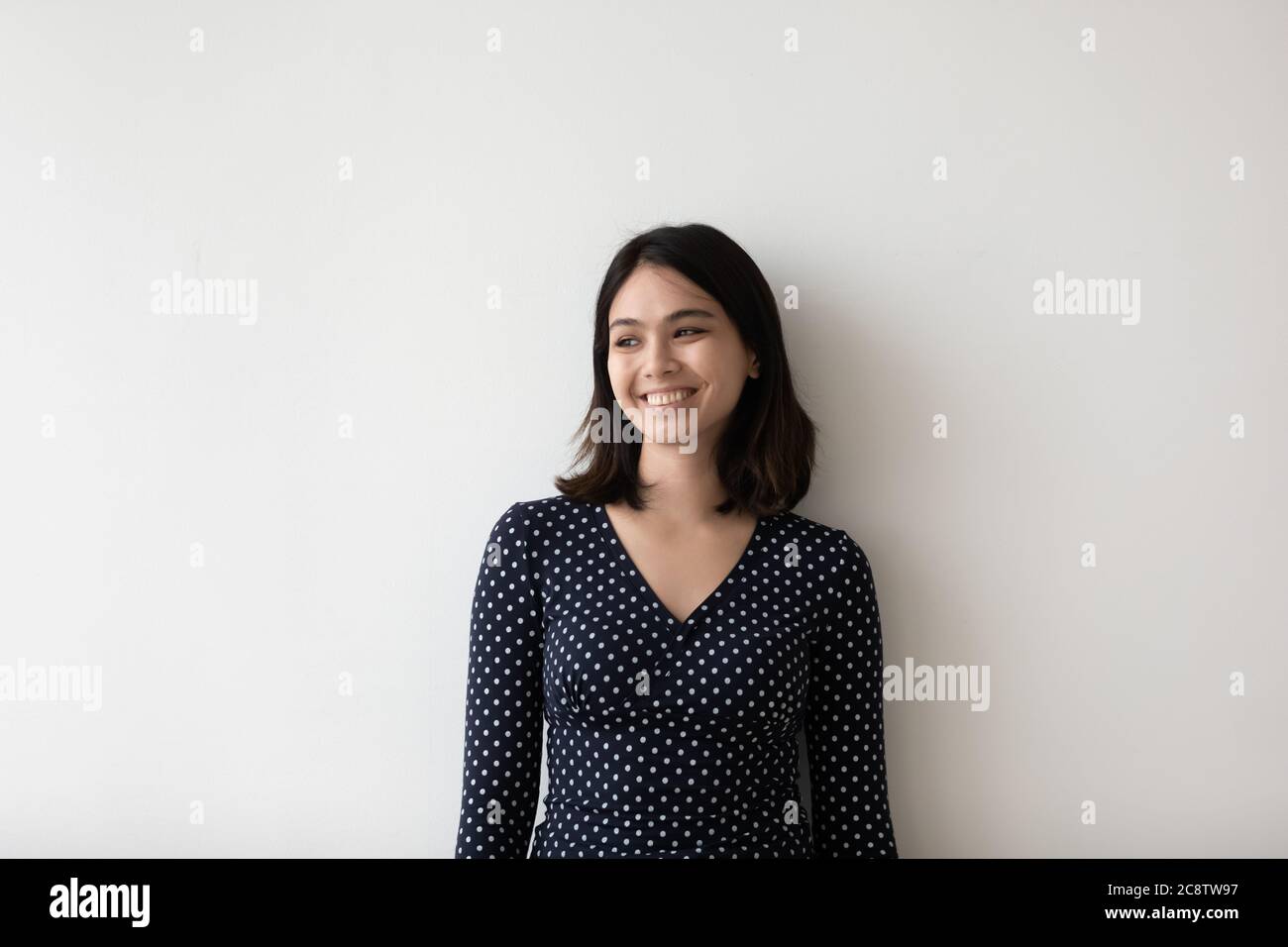Smiling Asian girl look in distance dreaming Stock Photo - Alamy