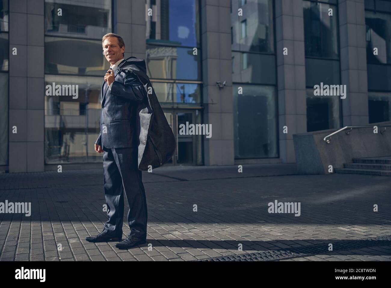 Joyful man in elegant suit standing on the street Stock Photo - Alamy