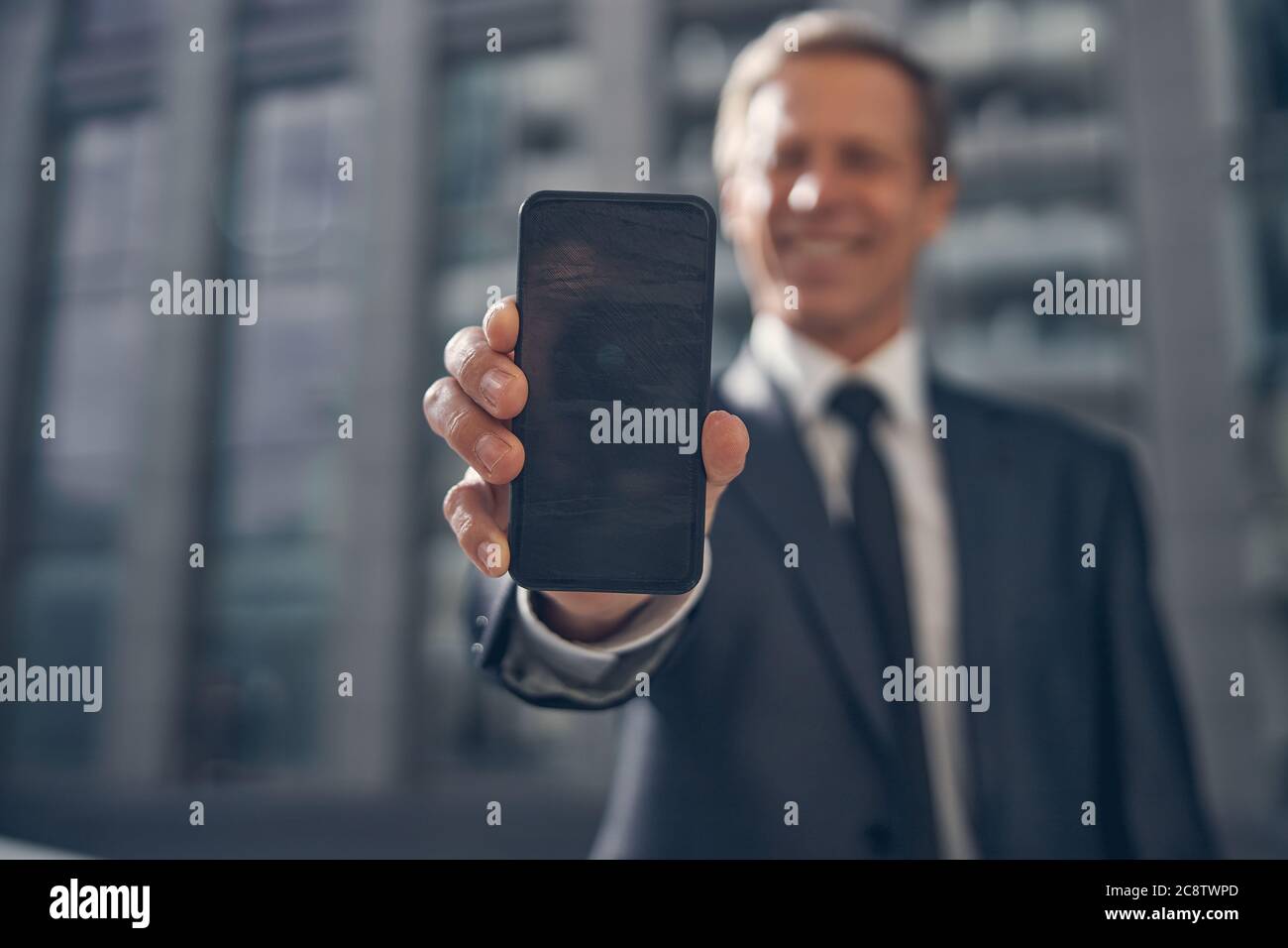 Man in suit holding modern mobile phone Stock Photo - Alamy