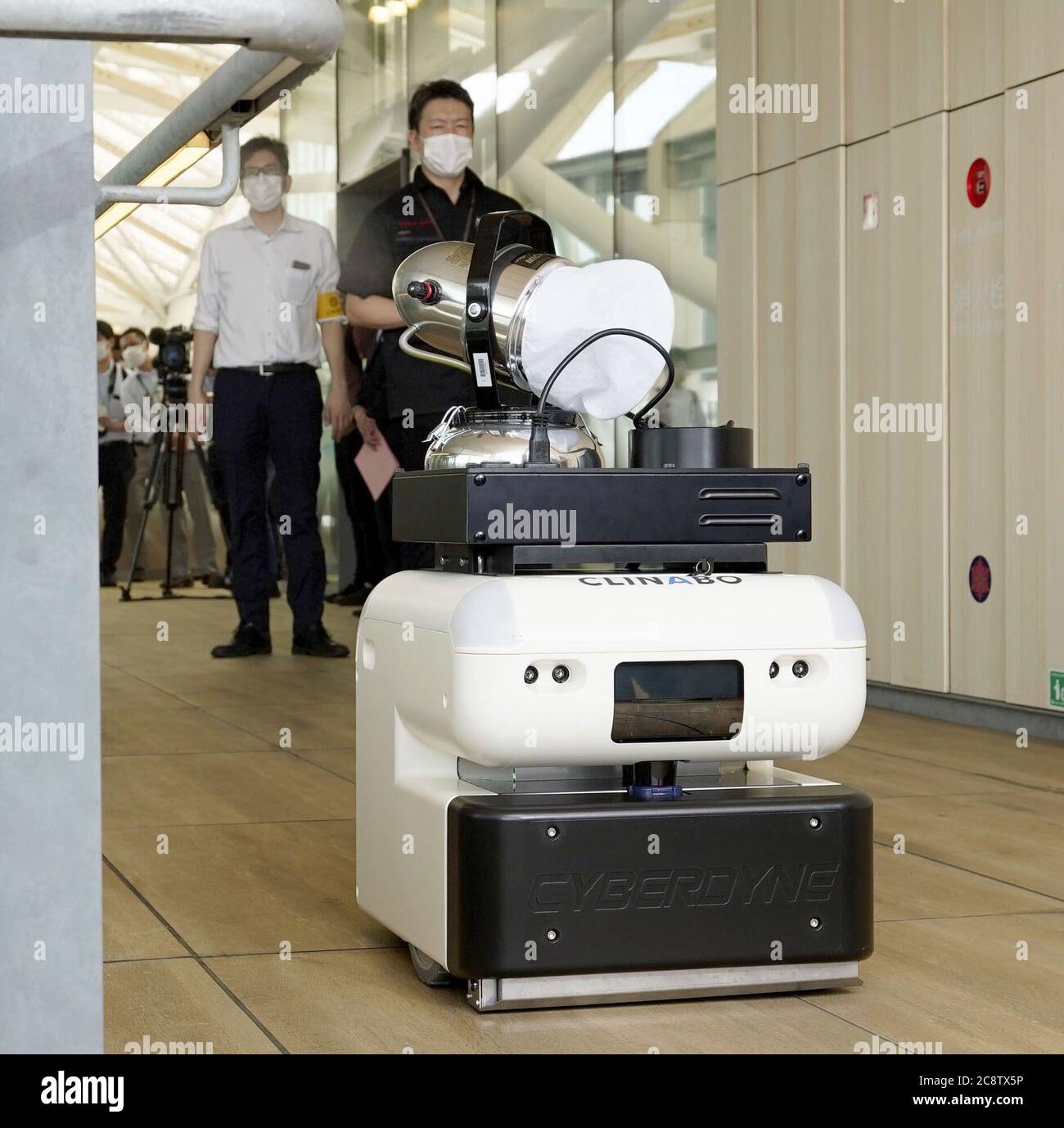 A cleaning robot sprays disinfectant to sanitize handrails and other ...