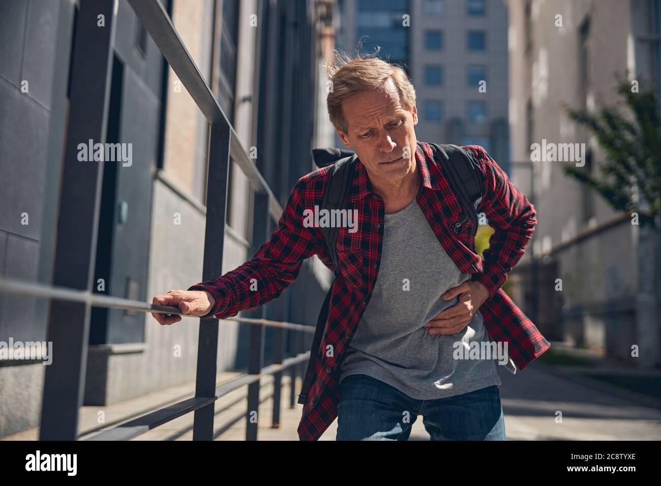 Unhappy man having pain in his left side outdoors Stock Photo - Alamy