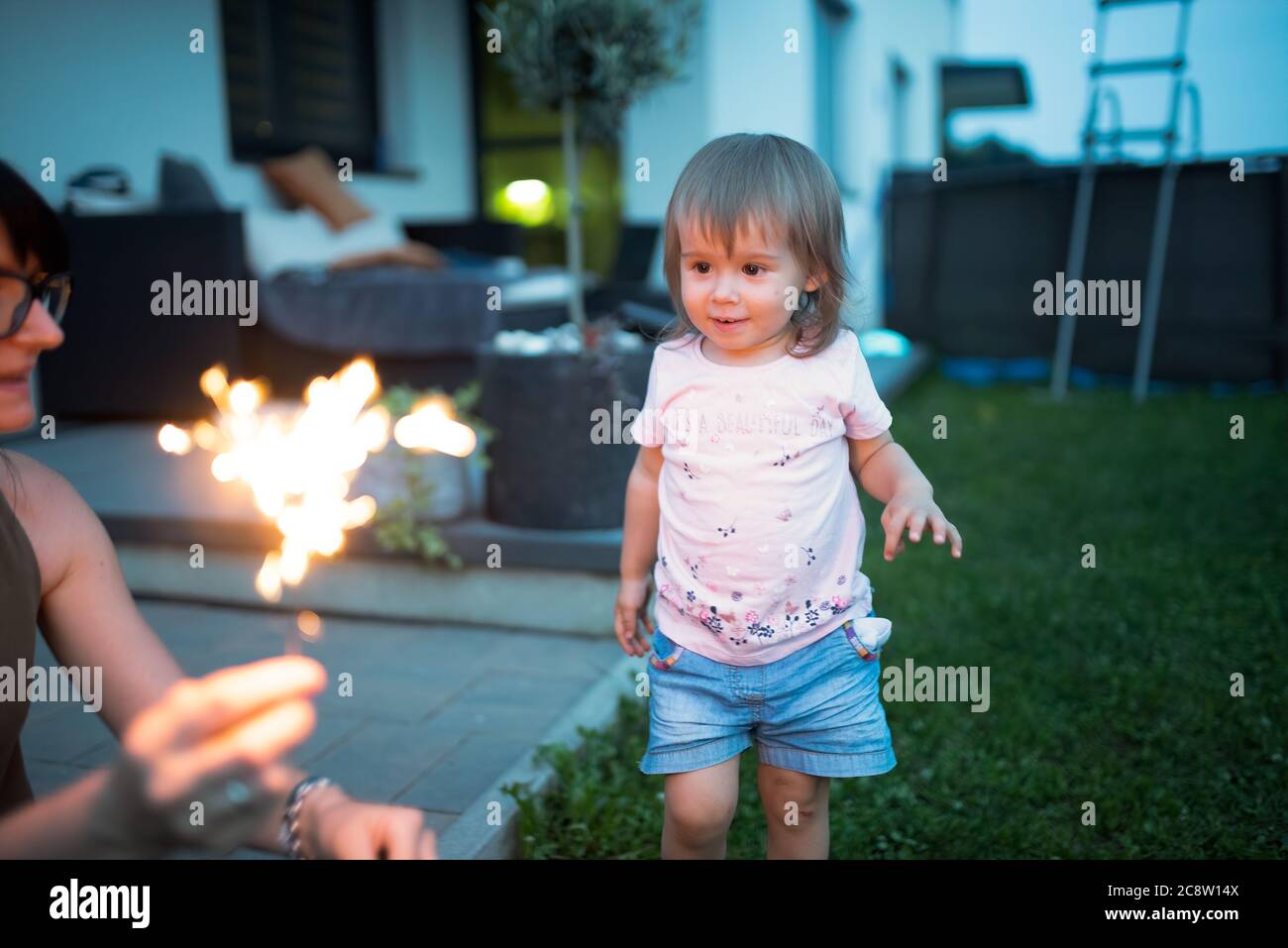 Child seeing sparkler fireworks first time outside Stock Photo - Alamy