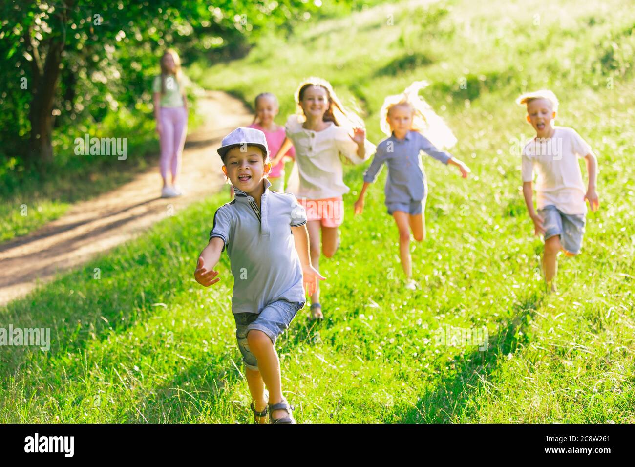 Kids, children running on meadow in summer's sunlight. Look happy ...
