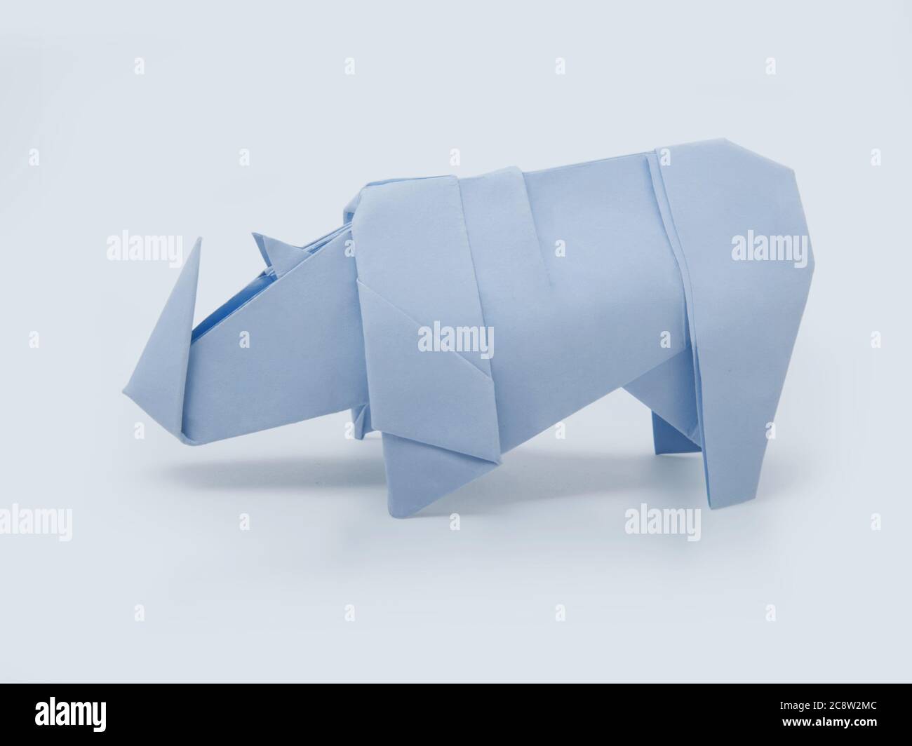 Origami cute rhinoceros on a blue background Stock Photo - Alamy
