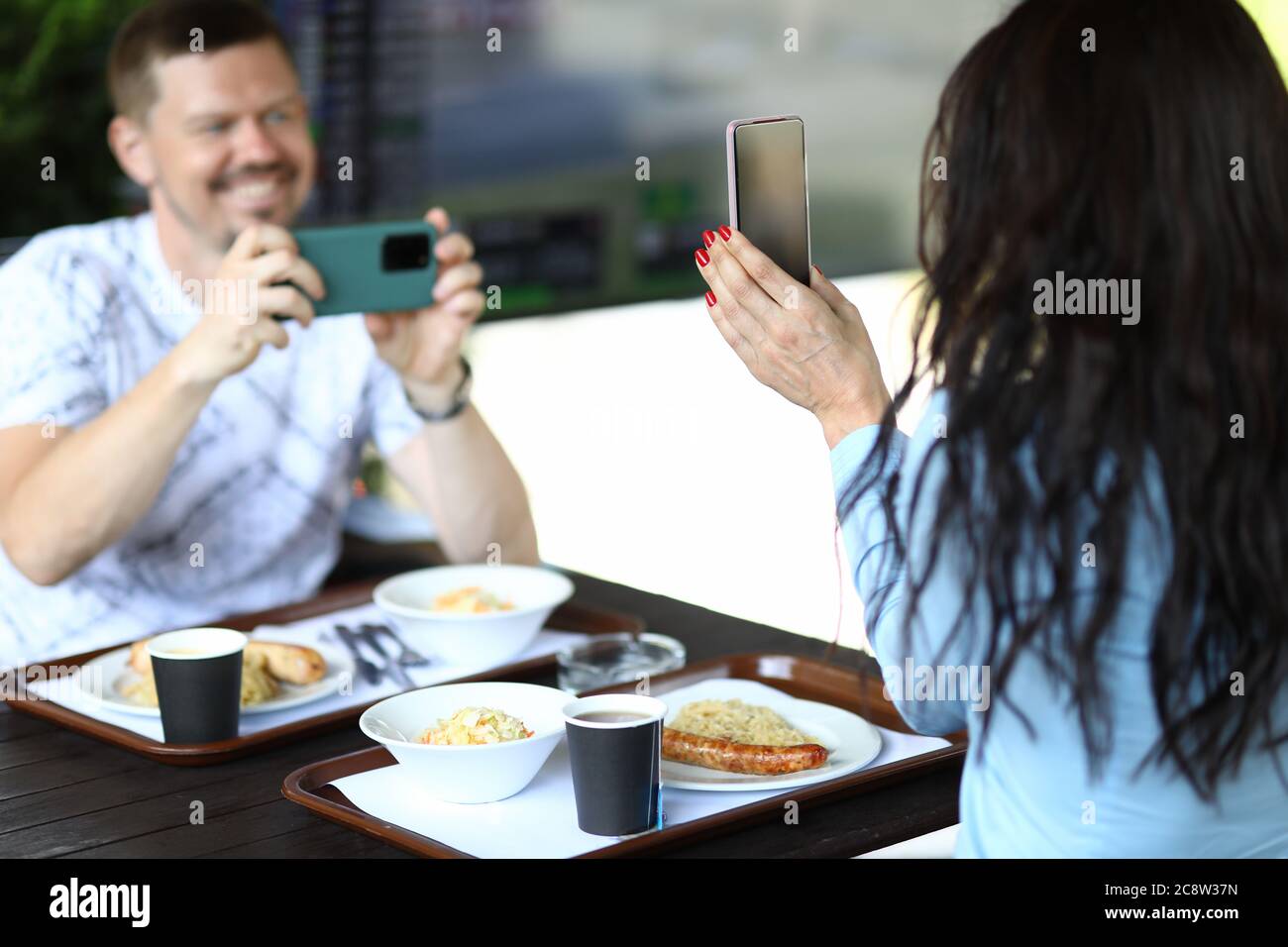 Woman is holding smartphone in her hands, man is filming review of ...