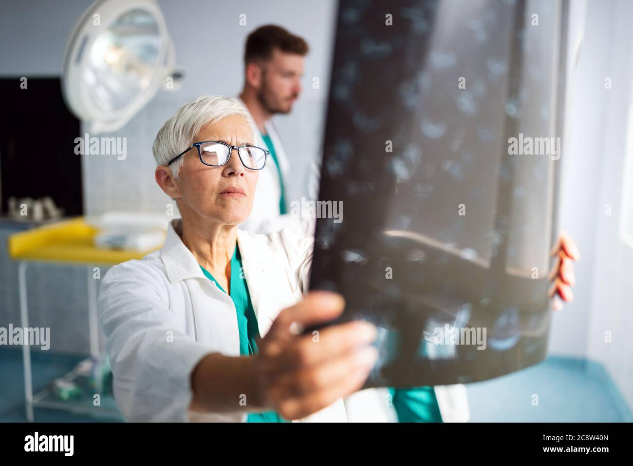 Doctors discussing patient's diagnosis looking at x-rays in a hospital ...