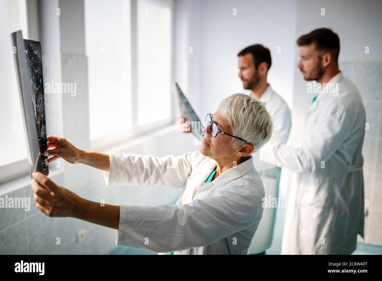 Medical team doctors checking on X-ray results in hospital Stock Photo ...