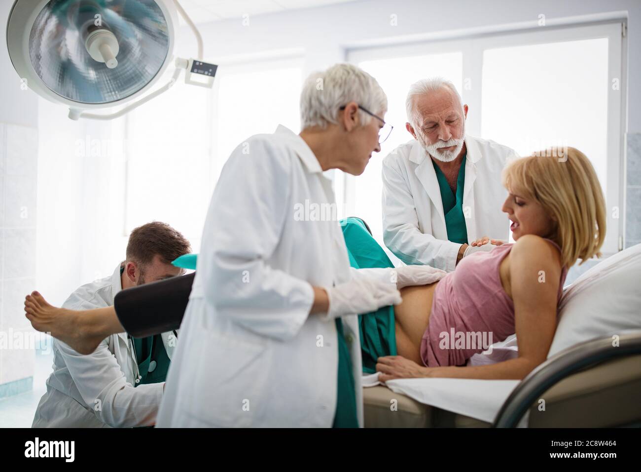 In the hospital woman in labor pushes to give birth, obstetricians ...