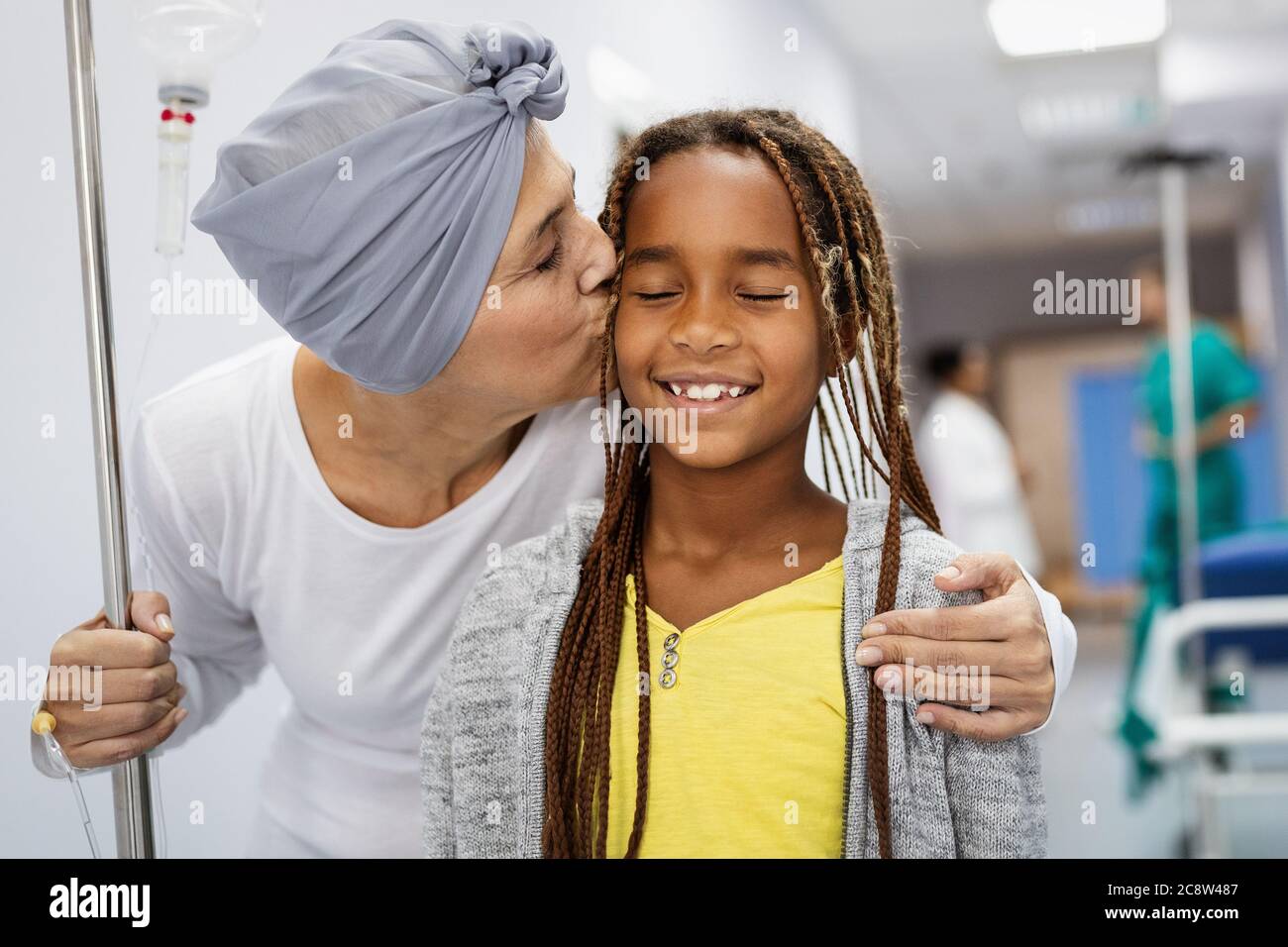Sick woman with cancer hugging her young grandchild in hospital. Family ...