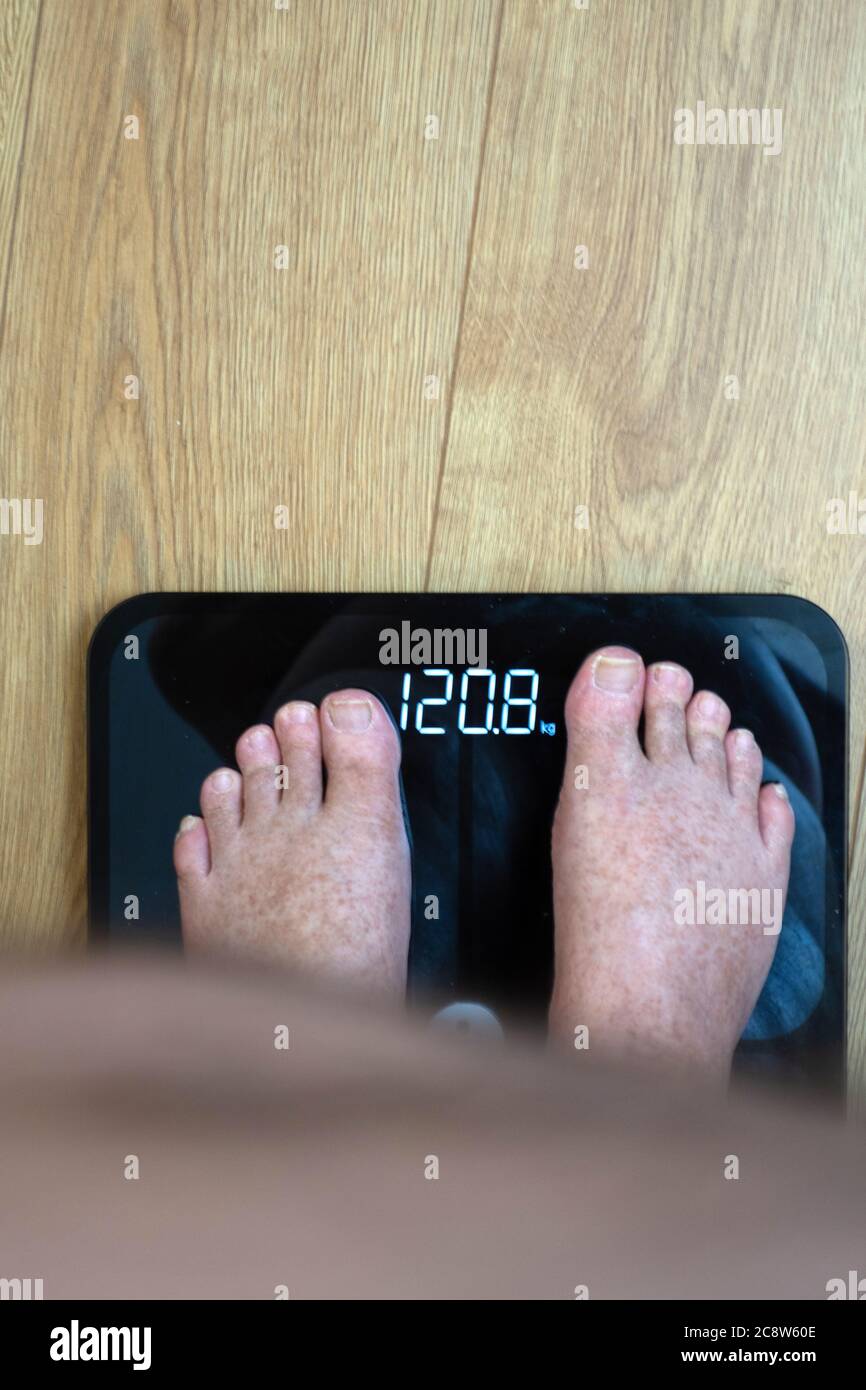 Obese man's point of view looking at his feet and his weight on the ...