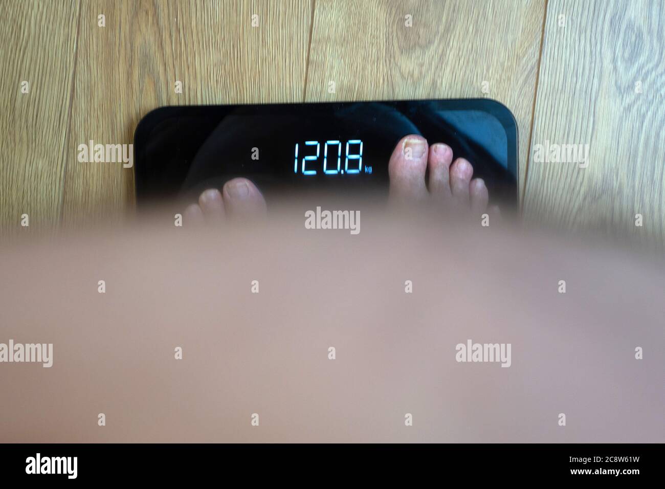 Obese man's point of view looking at his feet and his weight on the ...