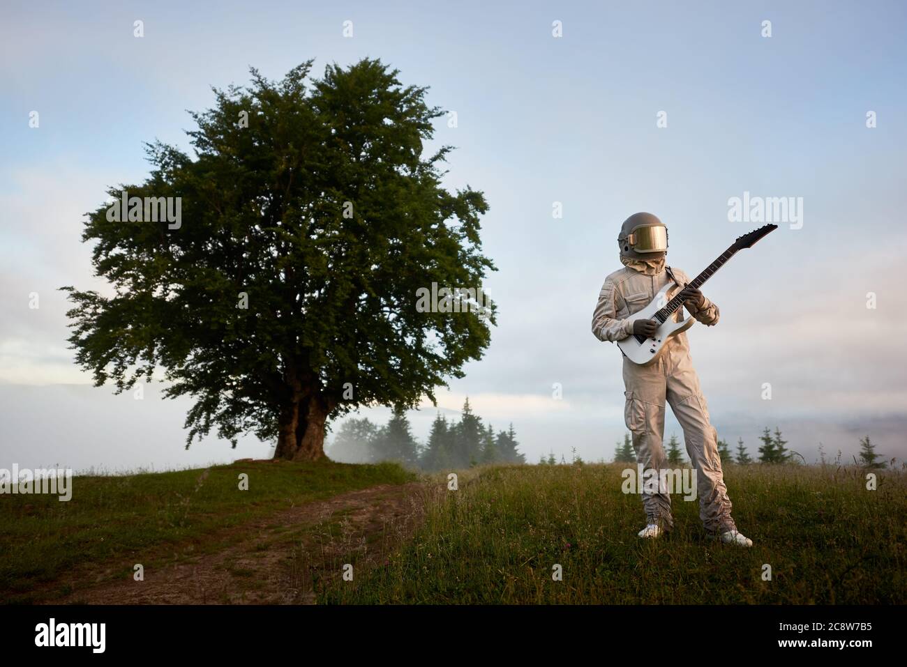 Astronaut guitarist in space suit and helmet with musical instrument ...