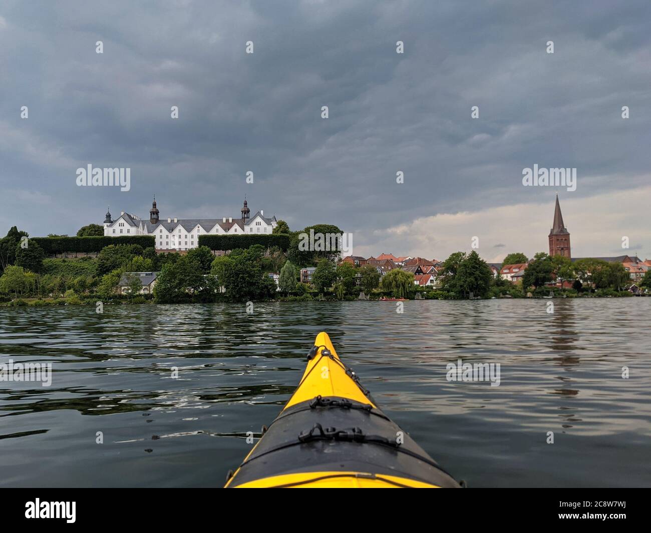 Ploen, Germany, yellow kayak on great ploner ploener lake in background plon castle, dark sky ...