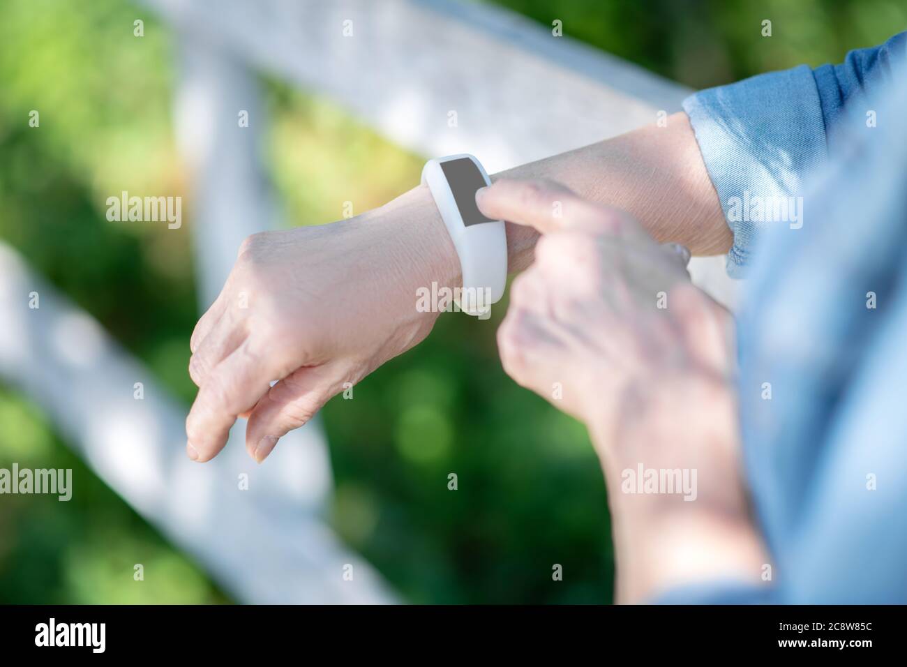 Elderly woman using smartwatch during her walk Stock Photo - Alamy