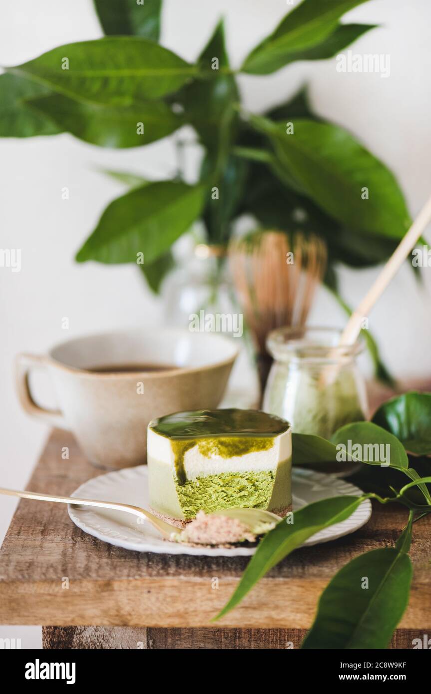 Green matcha cheesecake and black coffee on kitchen counter Stock Photo ...