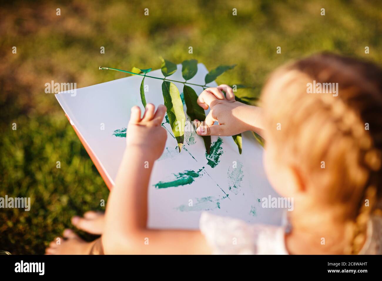 Cute little caucasian kid girl drawing or painting with colored paints ...
