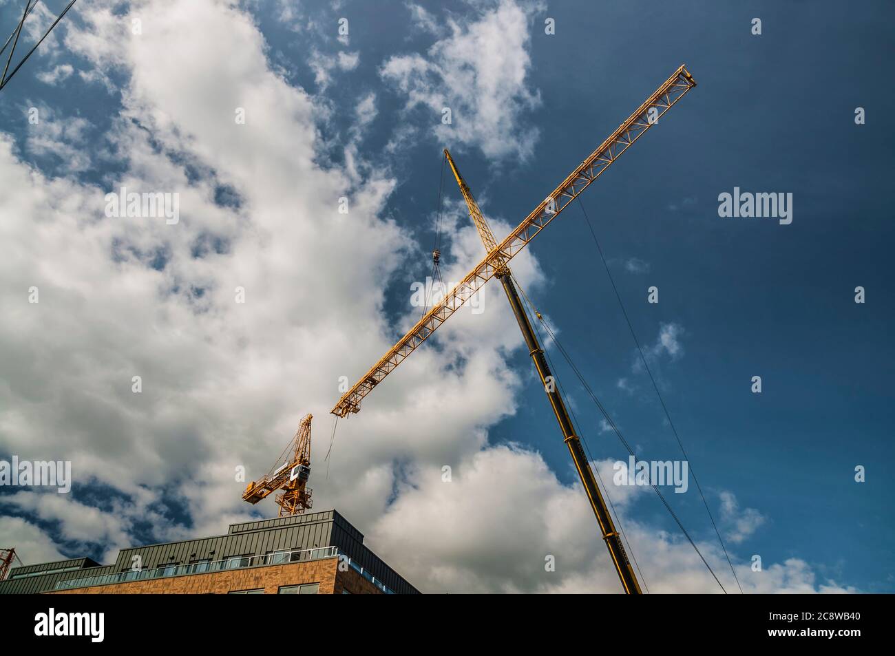 Mobile crane taking down tower crane during apartment construction in ...
