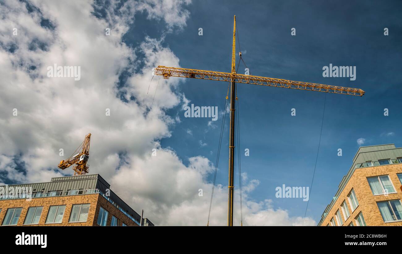 Mobile crane taking down tower crane during apartment construction in ...