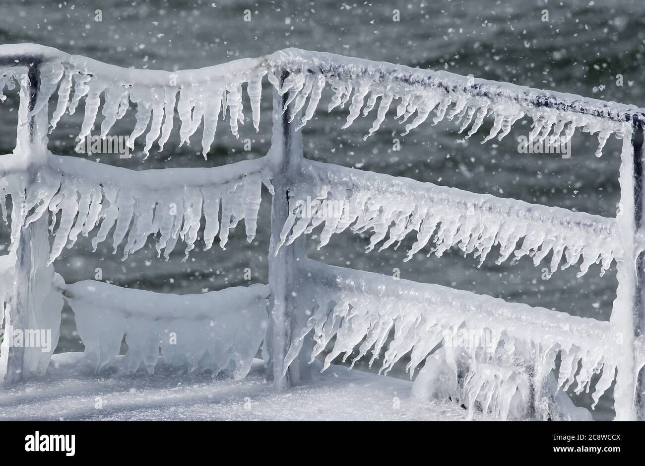 Huge icicles formed by waves hanging on frozen ship's rail, Baltic Sea ...