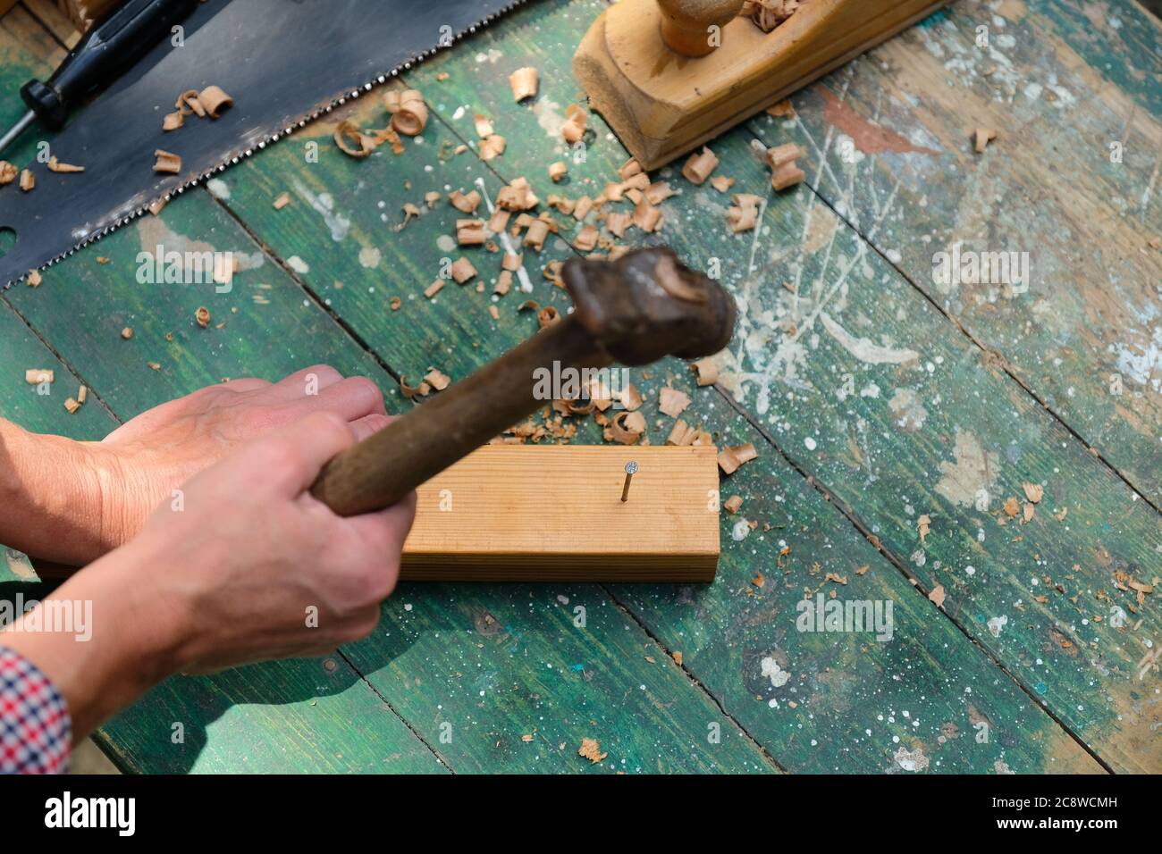 Carpenter using hammer hit the nail on wood, top view. Woodwork concept ...