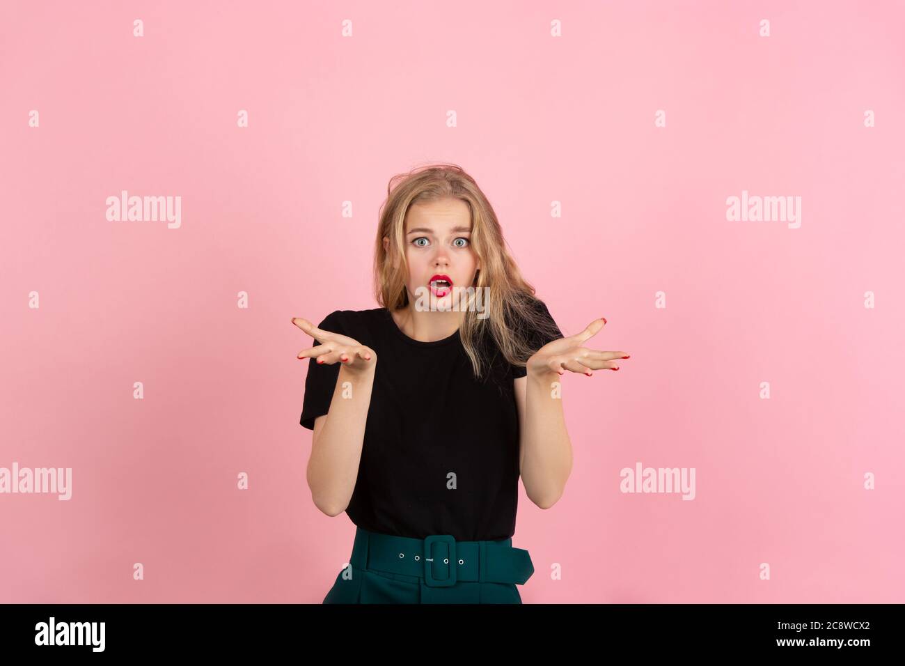 Asking, shocked. Portrait of young emotional woman gesturing isolated ...