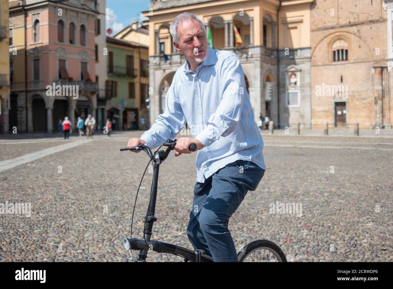 Man riding his bike in a city square Stock Photo - Alamy