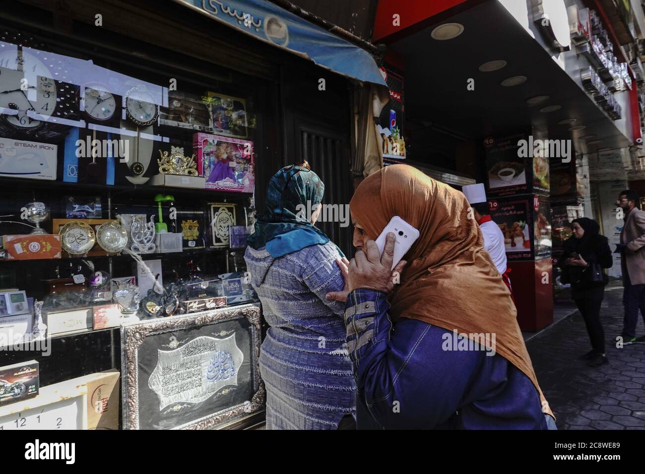 Cairo, Egypt Two women on a sidewalk in front of a store in the Dokki ...