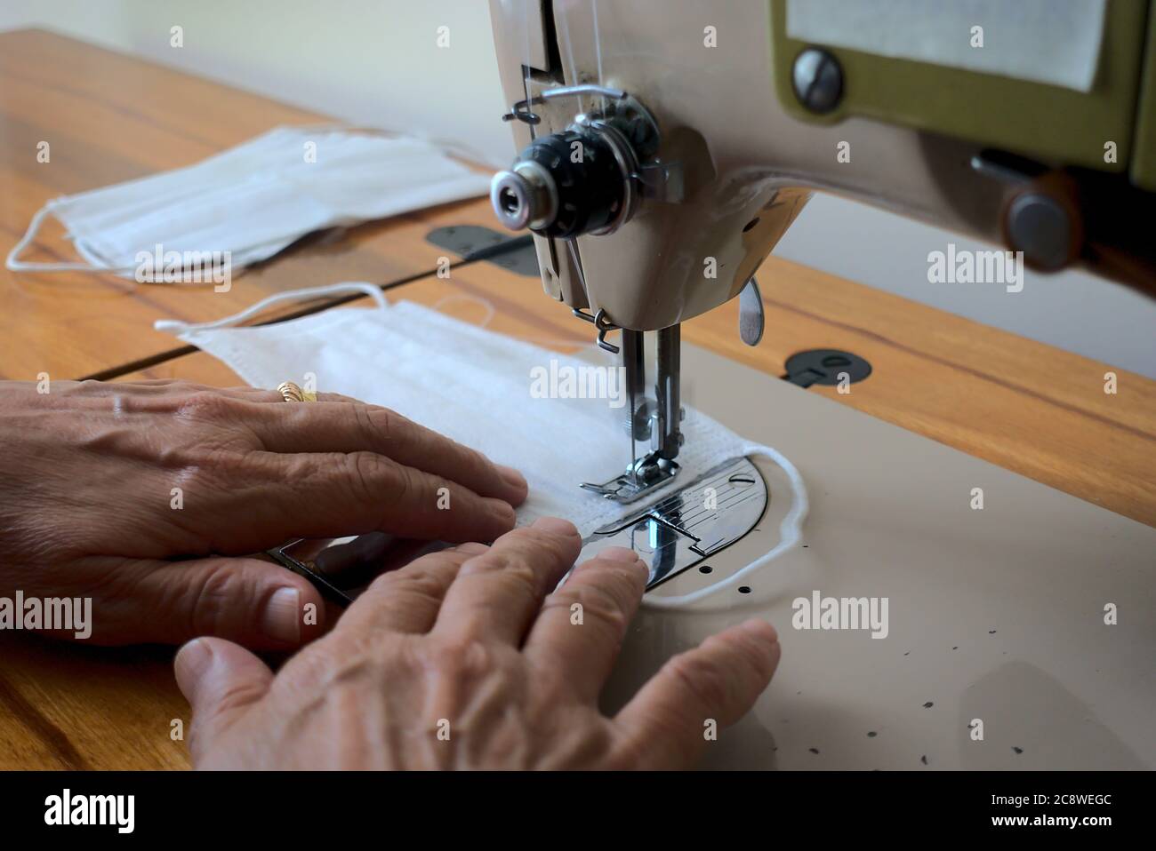 Close up shot woman wearing wedding ring manufacturing surgical mask ...