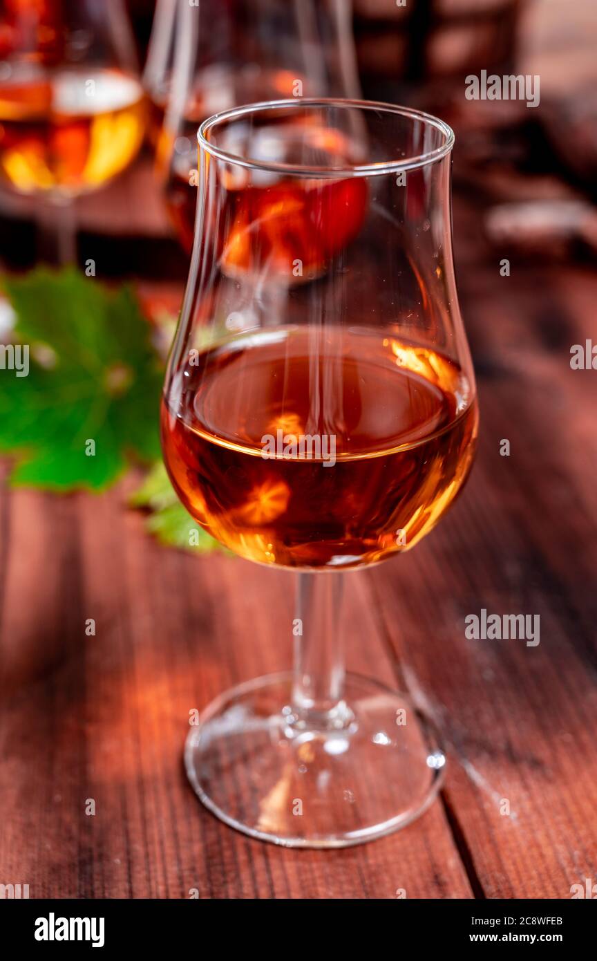 Tasting glasses with aged french cognac brandy in old cellars of cognac ...