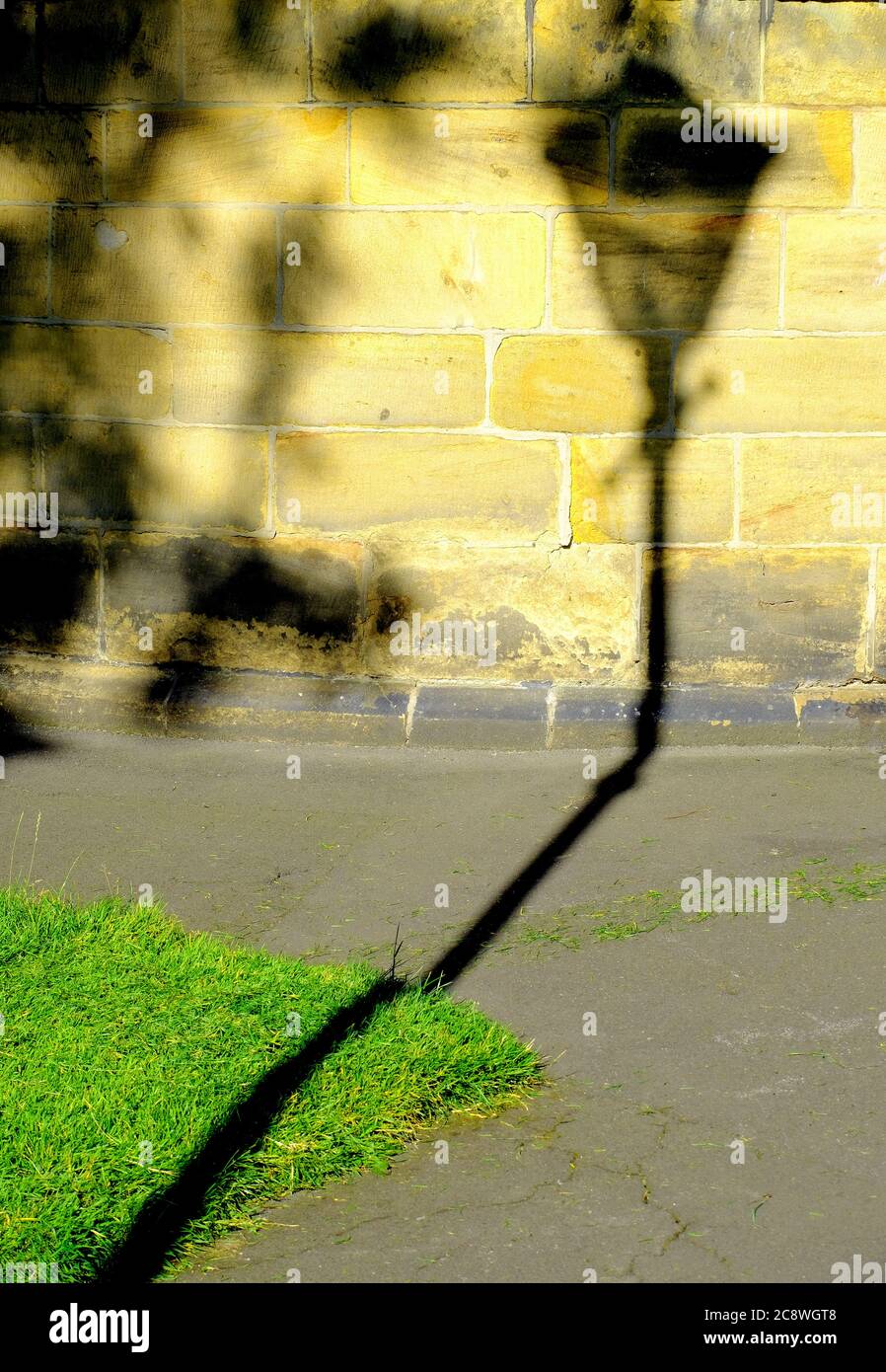 Old lamp post shadow against ancient stone church wall Stock Photo - Alamy
