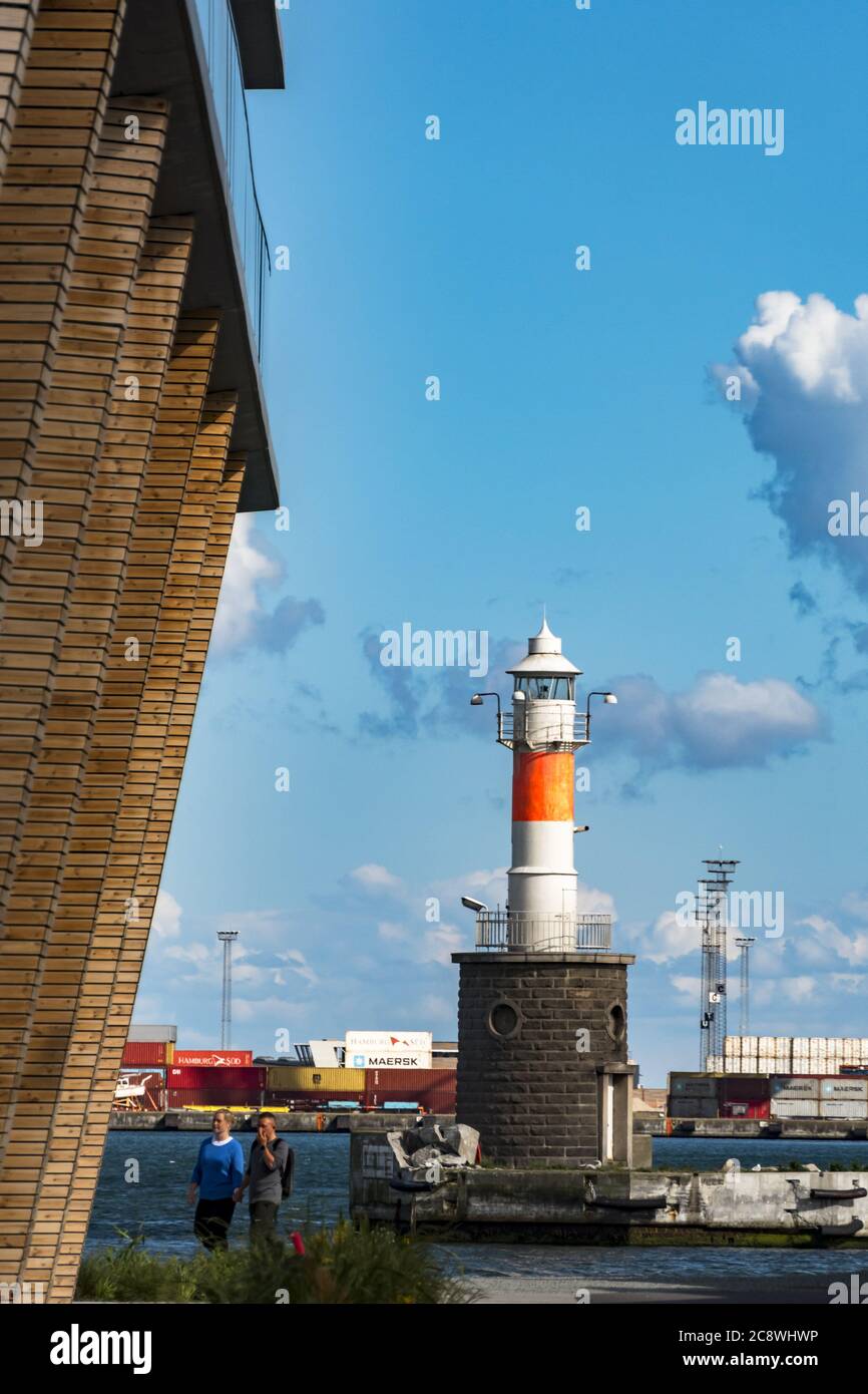 Aarhus, Denmark People walk by an old lighthouse in the new Docklands ...