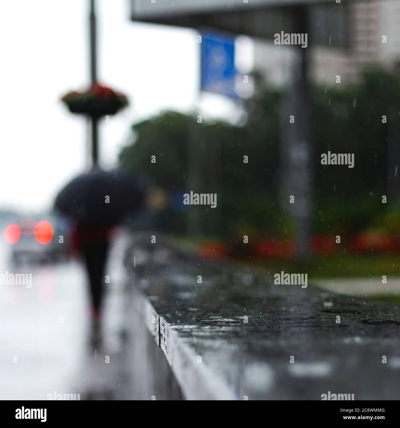 Urban landscape in the rain. Drops on the parapet along the sidewalk ...