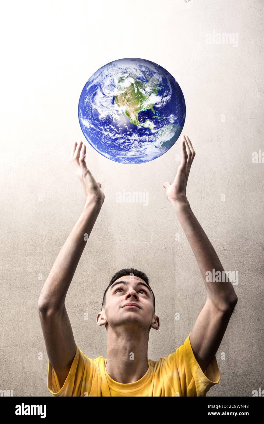 a Boy stretching arms to grab planet Earth Stock Photo - Alamy
