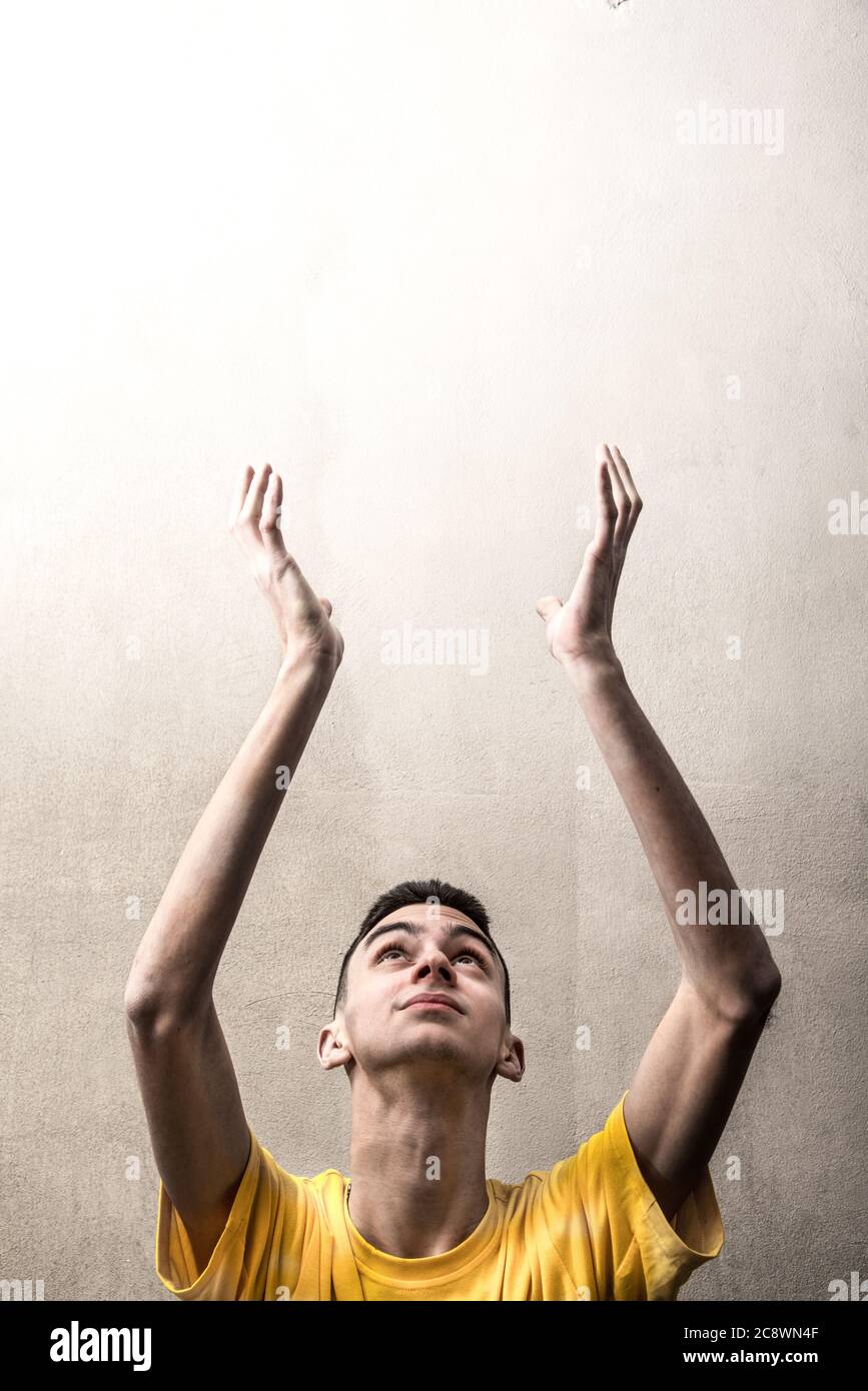 a Young man lifts his arms upwards Stock Photo - Alamy