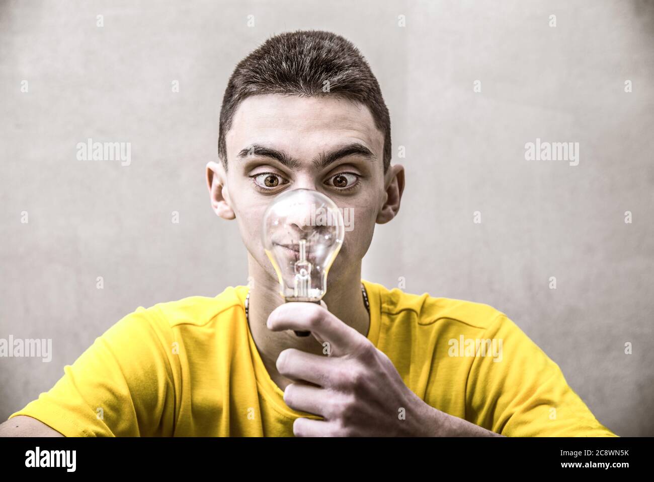 a Boy looking curiously at a lightbulb Stock Photo - Alamy
