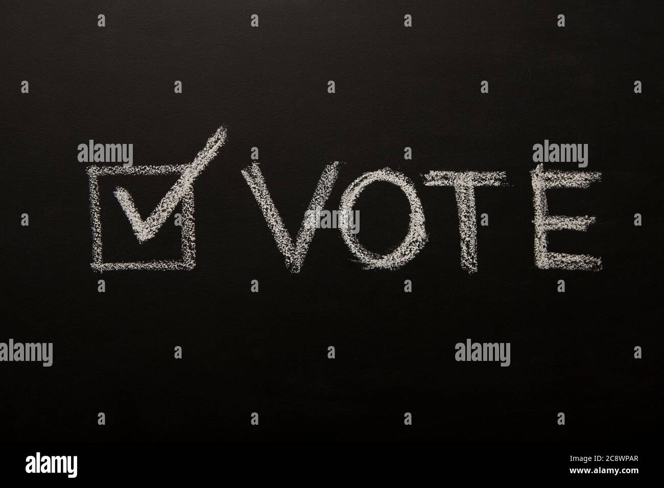 Vote tick on chalkboard, black background, elections 2020 Stock Photo ...