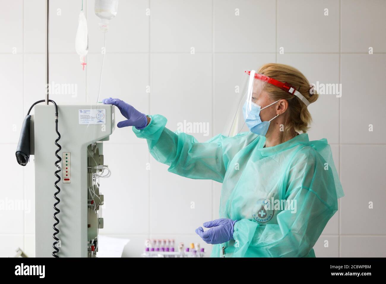 Dressed in protective clothing, a employee of a blood donation station ...
