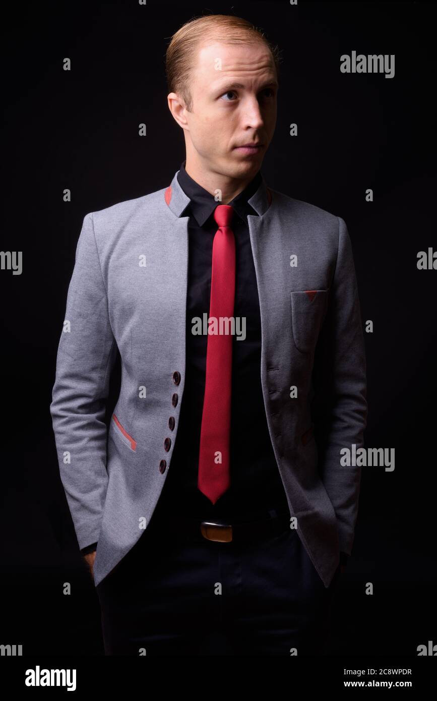 Businessman with blond hair against black background Stock Photo - Alamy