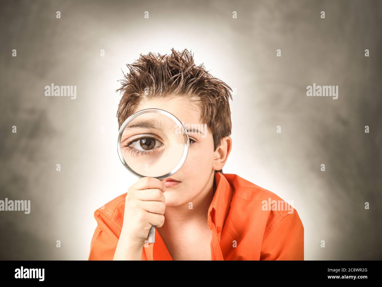 Little boy looking with a magnifying glass Stock Photo - Alamy