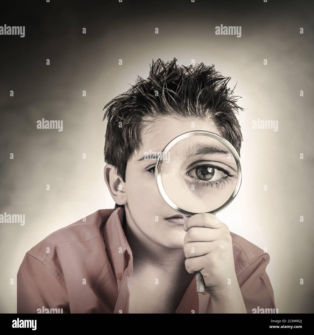 Little boy looking with a magnifying glass Stock Photo - Alamy