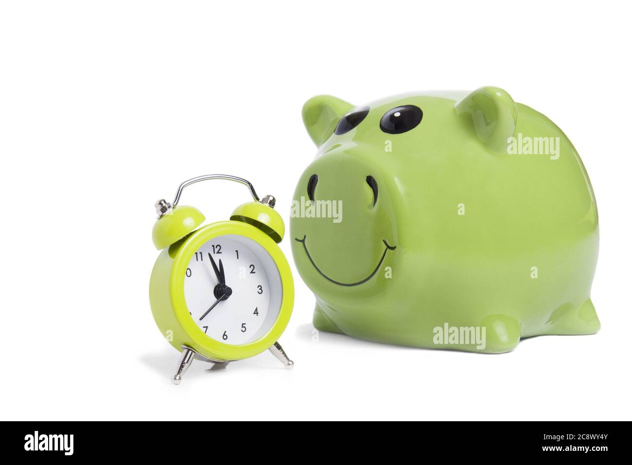 Yellow clock and a green piggy bank on white background - time is money ...
