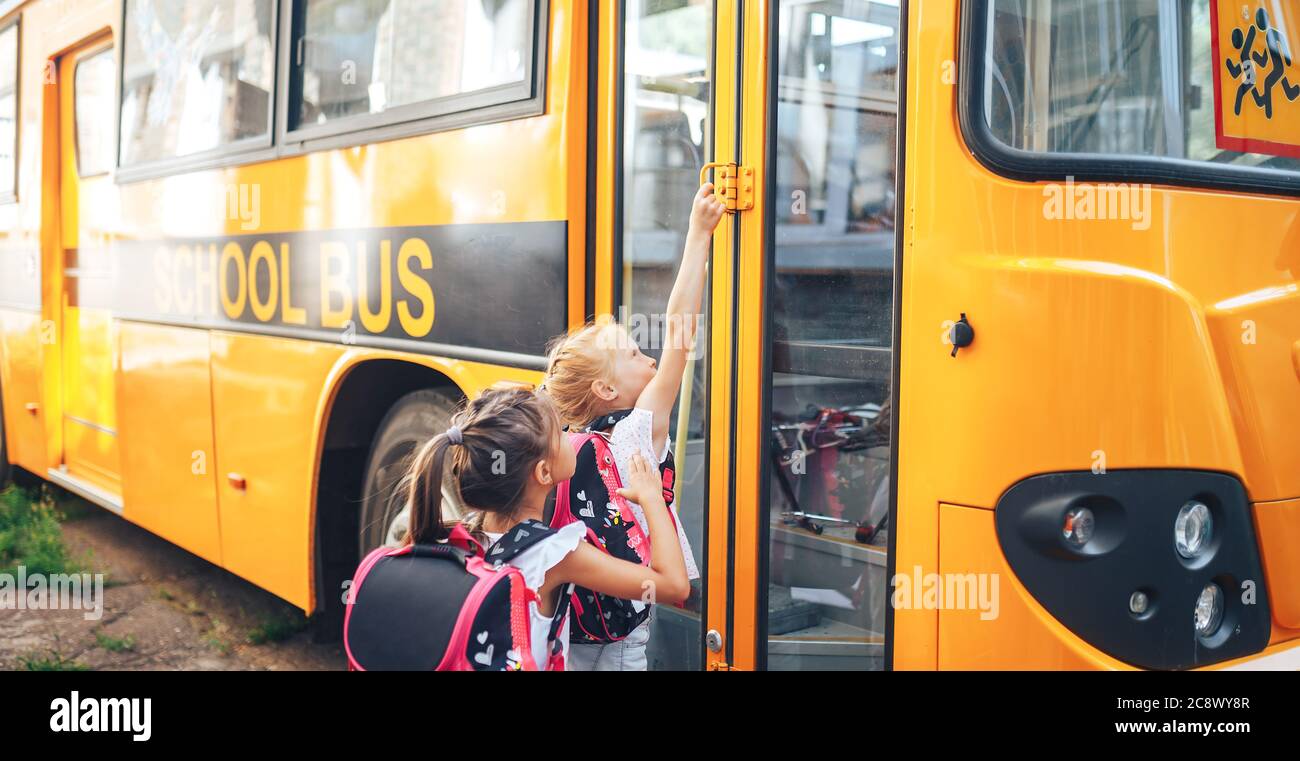 Schoolgirls with backpacks enter the school bus, back to school Stock ...