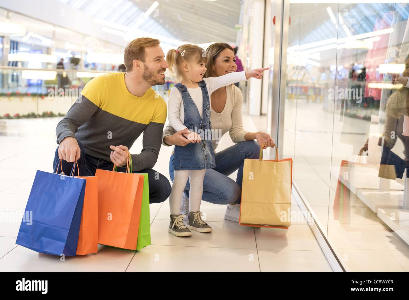 Shallow focus shot of a child doing shopping with her parents in the ...
